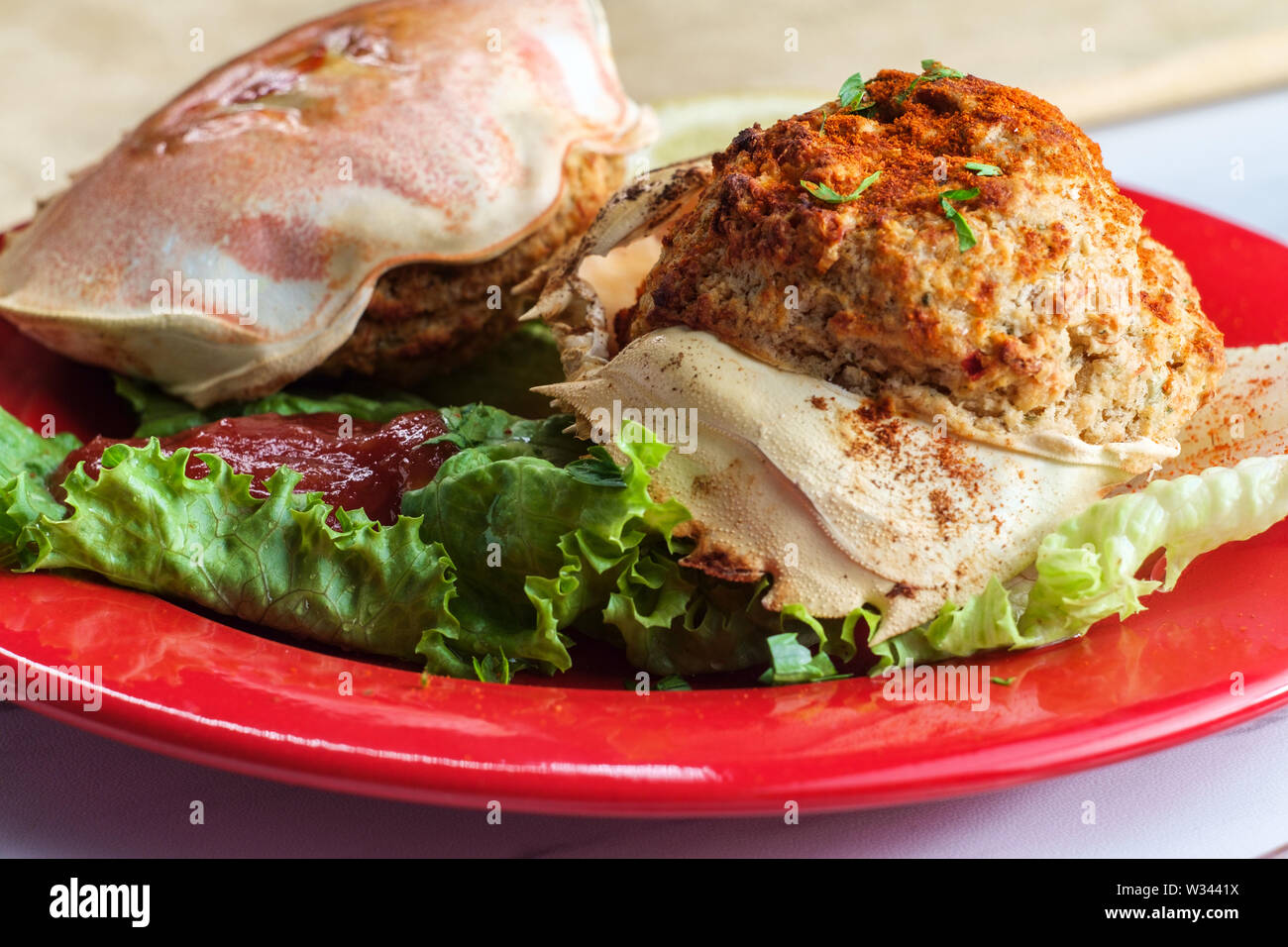 Stuffed seasoned crab shells garnished with romaine lettuce and sliced ...