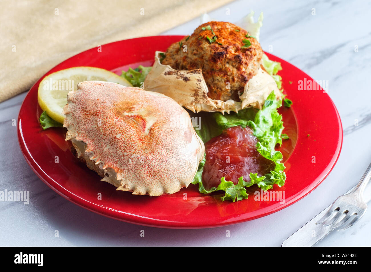 Stuffed seasoned crab shells garnished with romaine lettuce and sliced ...