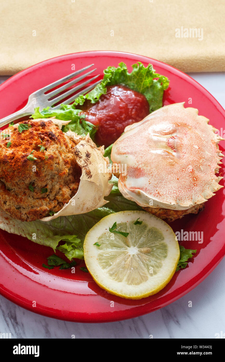 Stuffed seasoned crab shells garnished with romaine lettuce and sliced ...
