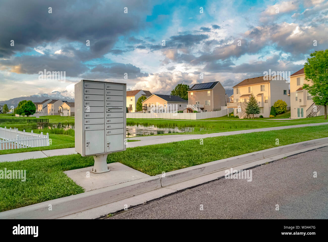 Mailbox on the side of the road with pond grassy terrain and homes ...