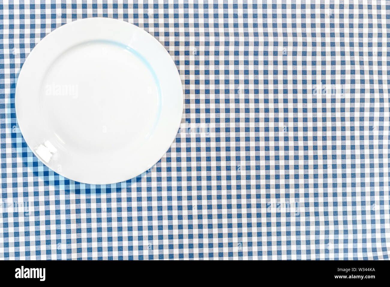 table with blue picnic cloth and plate Stock Photo - Alamy
