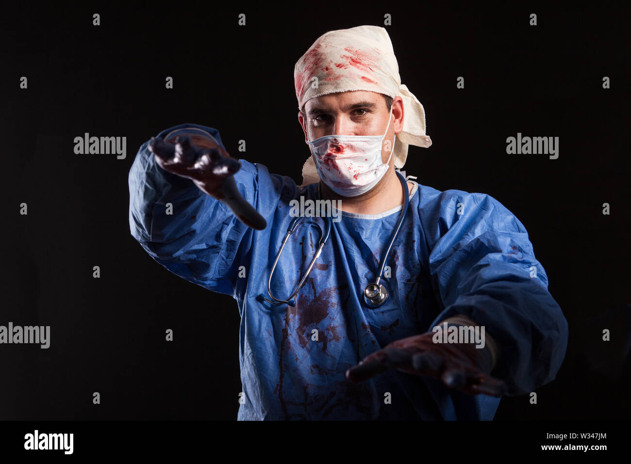 Portrait young man in crazy doctor clothes reaching out with his hands ...