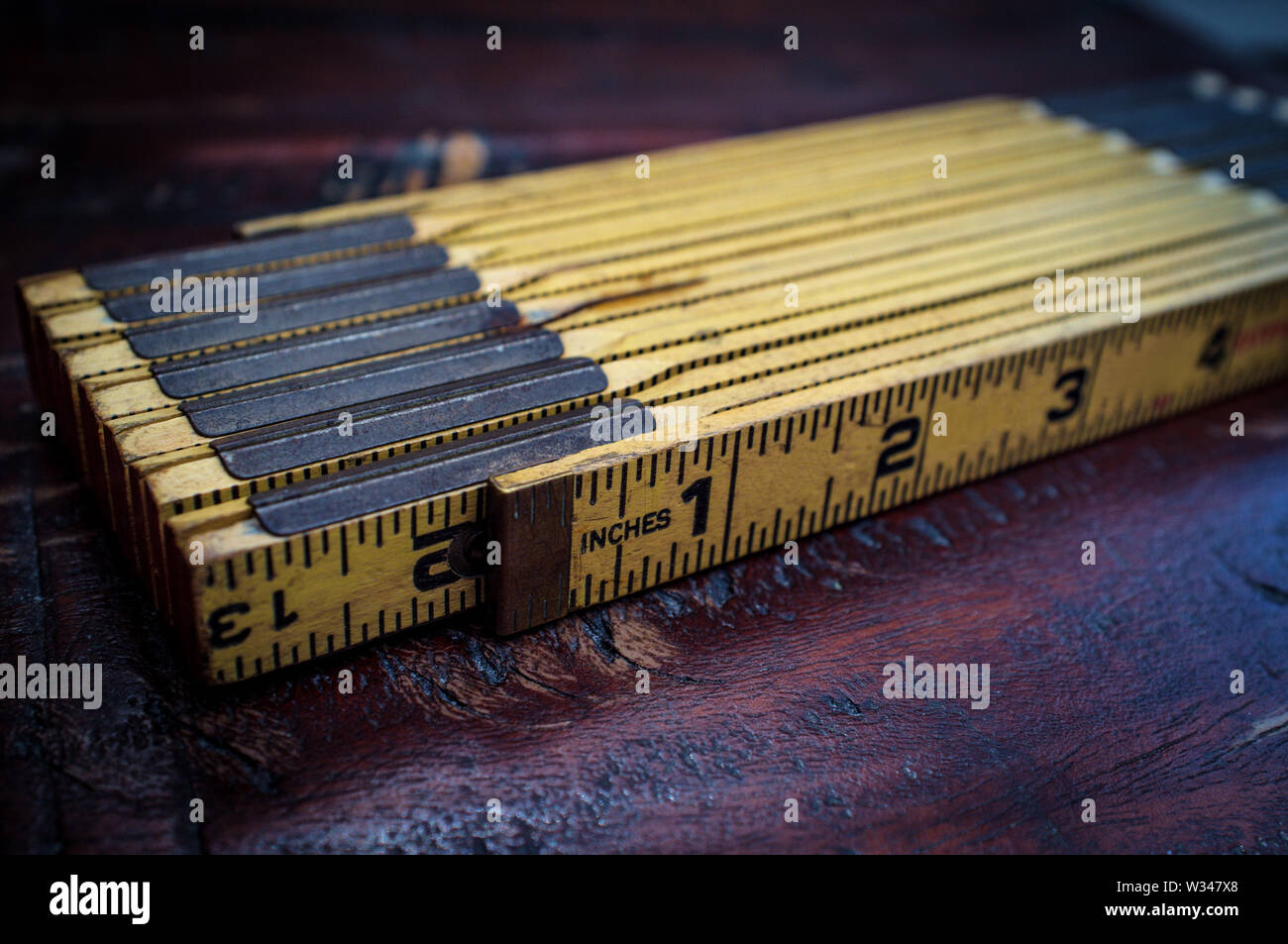 Old imperial folding ruler marked in inches on worn wooden floor Stock ...