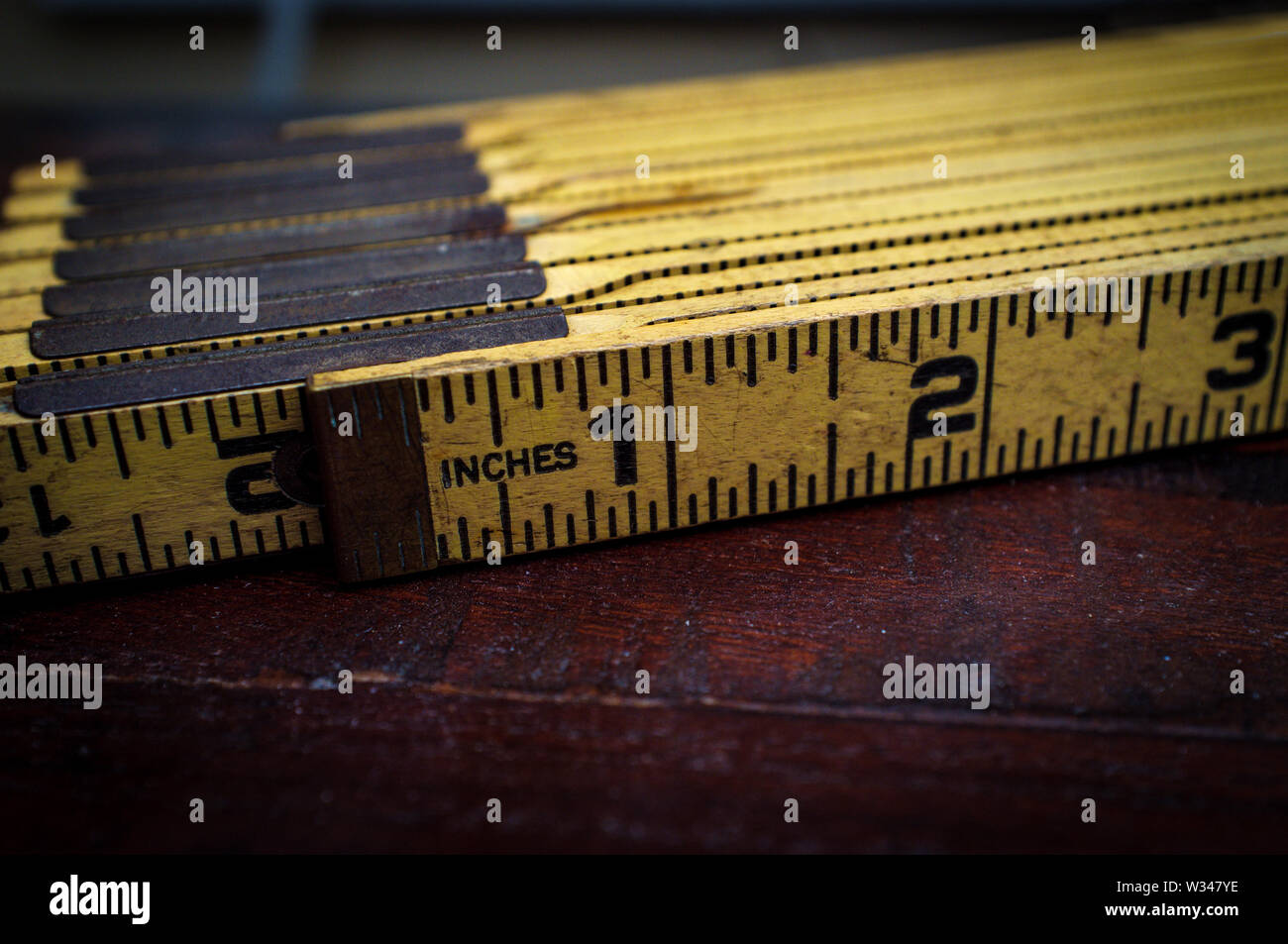 Old imperial folding ruler marked in inches on worn wooden floor Stock ...