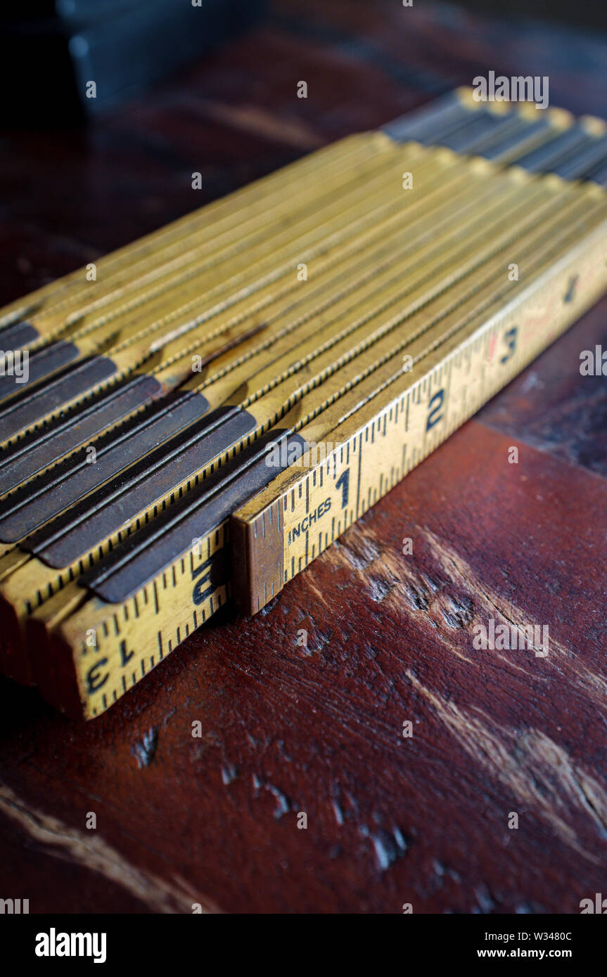 Old imperial folding ruler marked in inches on worn wooden floor Stock ...