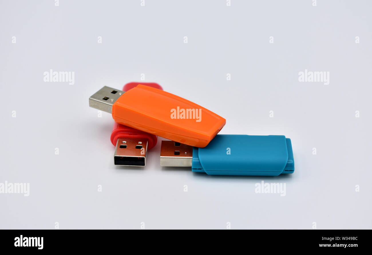 USB flash memory drives with colours, orange, blue and red, on a white ...