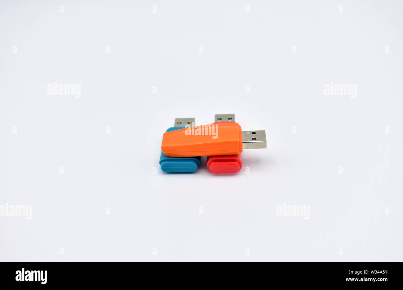 USB flash memory drives with colours, orange, blue and red, on a white ...