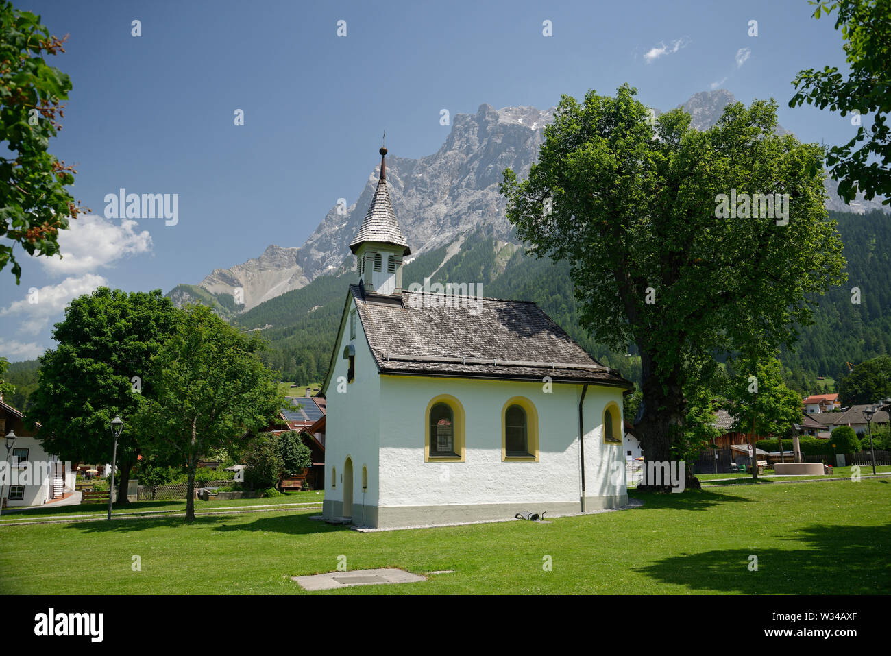 Alpine village of Ehrwald in Austria. Church painted white with ...