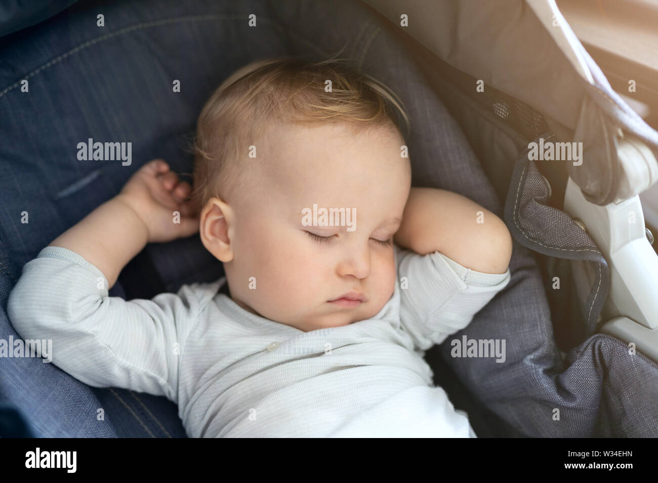 Cute adorable caucasian blond toddler bou sleeping in stroller at ...