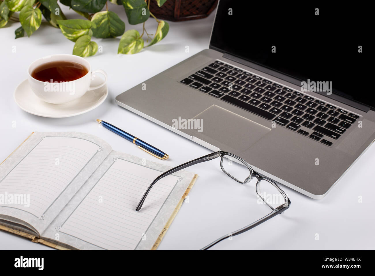White office desktop with opened notebook, laptop cpmputer and ...