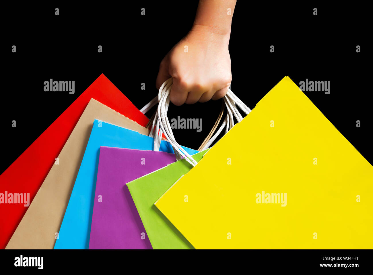 Hand holding colorful paper bags. Isolated on black. Ecological concept ...