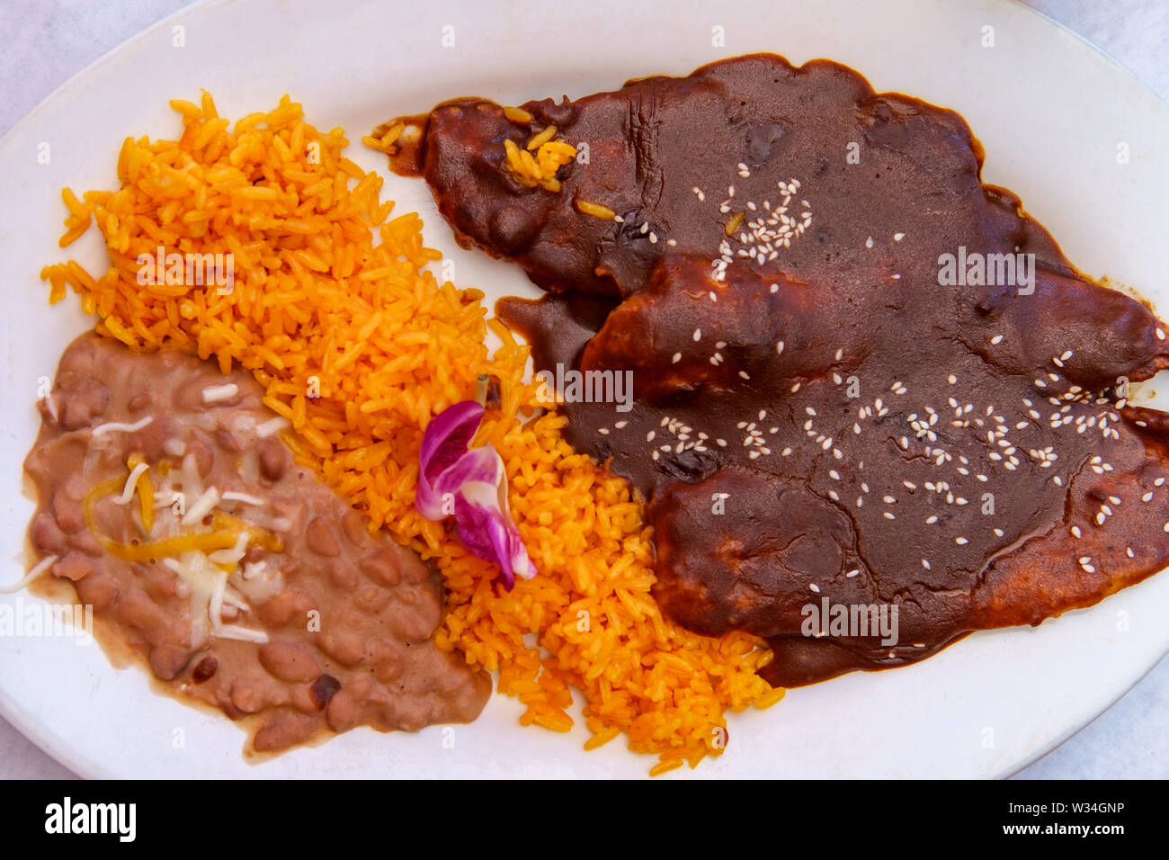 Mexican mole poblano chicken with rice and refried pinto beans Stock ...