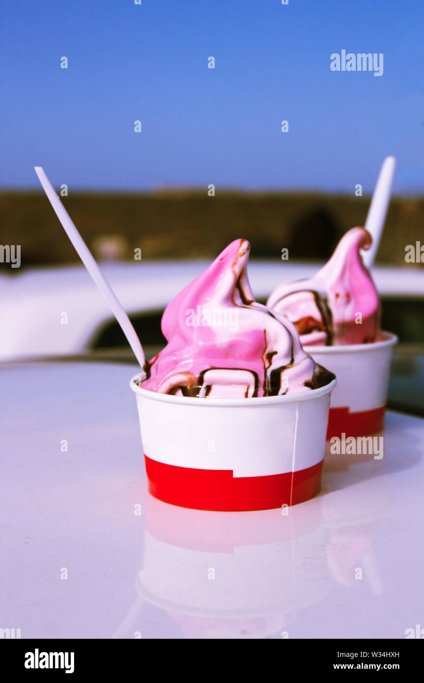 Two tubs of strawberry ice cream and fresh cream served on the roof of ...