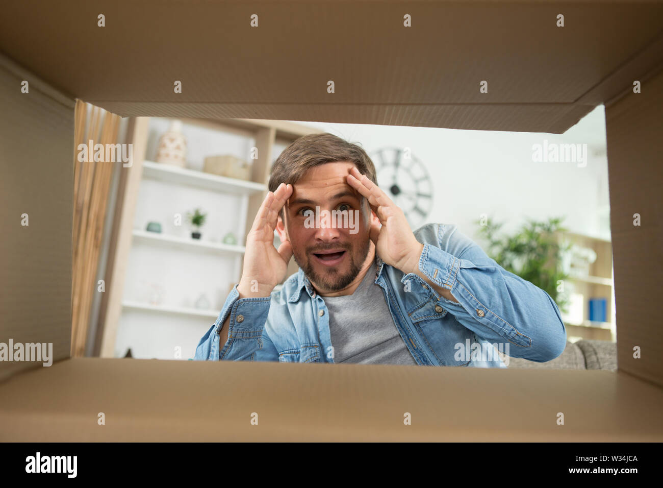 man smiling unpacking opening carton box and looking inside Stock Photo ...