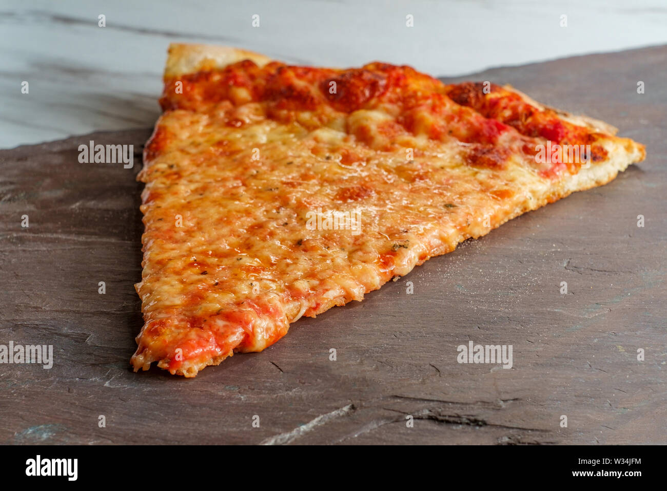 New York style plain slice of pizza on slate slab Stock Photo - Alamy