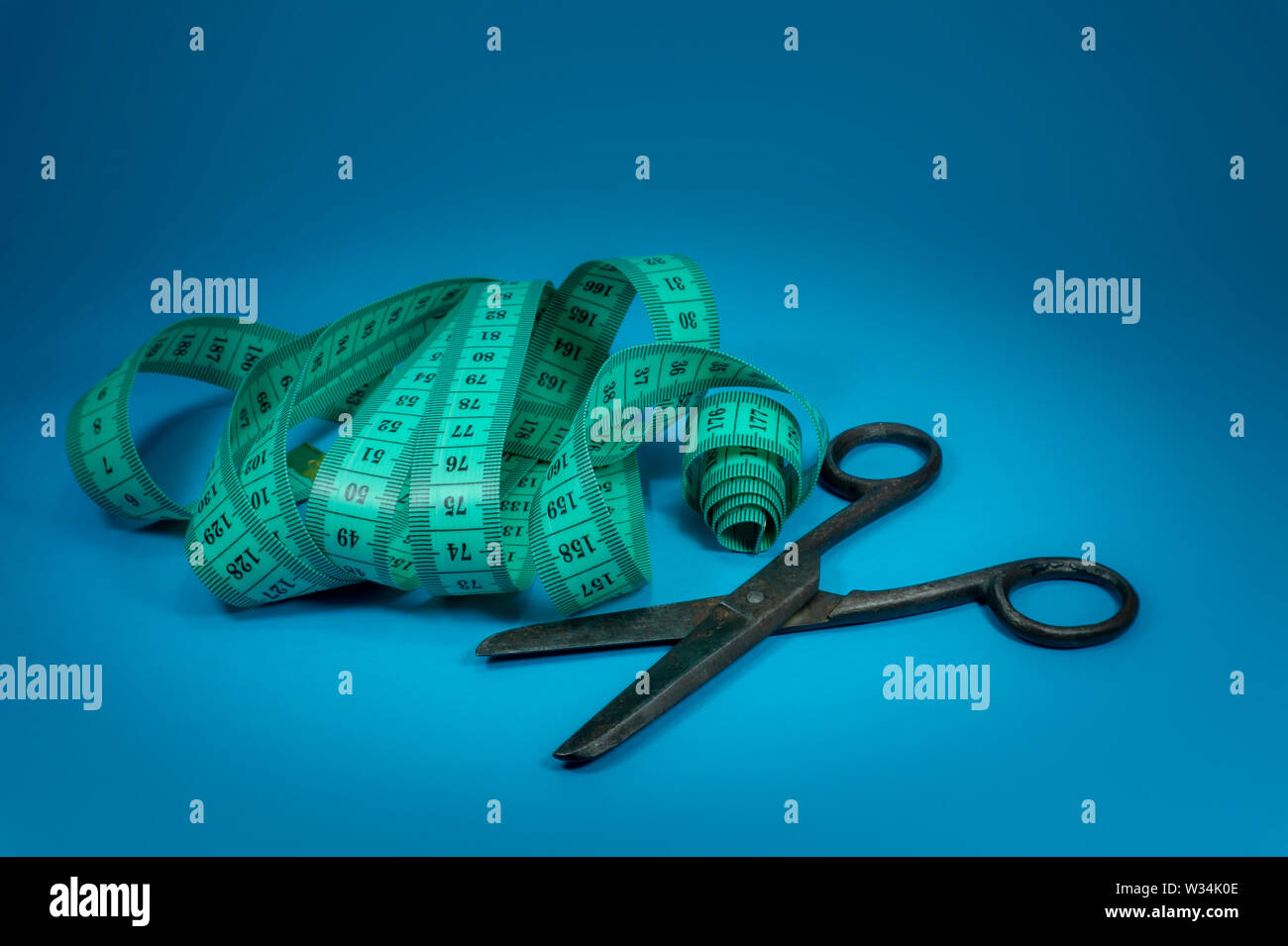 Vintage metal scissors with tape measure on blue background, needlework ...