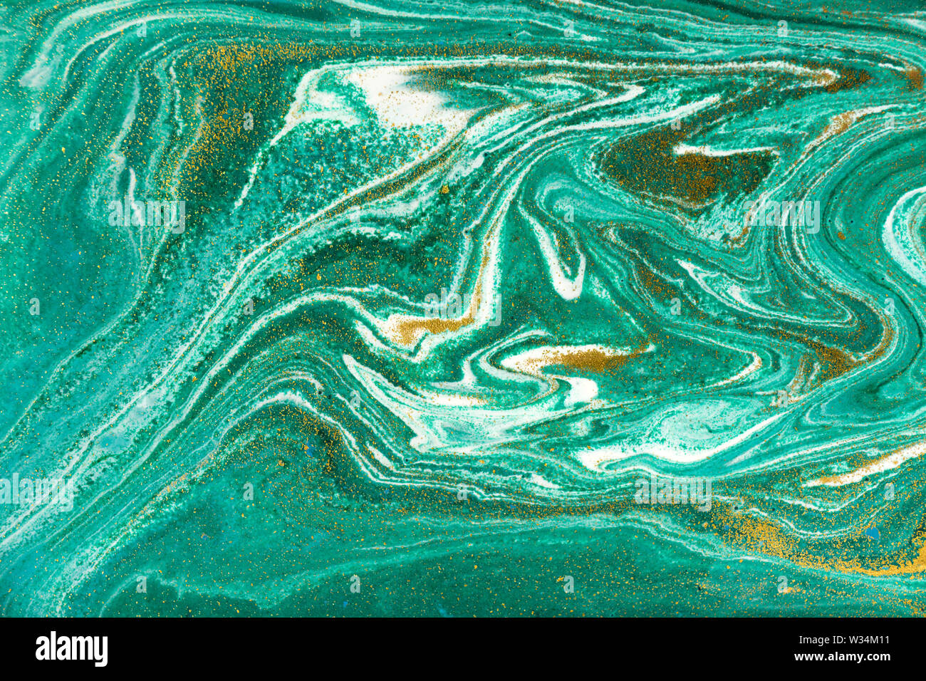 Liquid uneven green marbling pattern with golden glitter and glare of ...