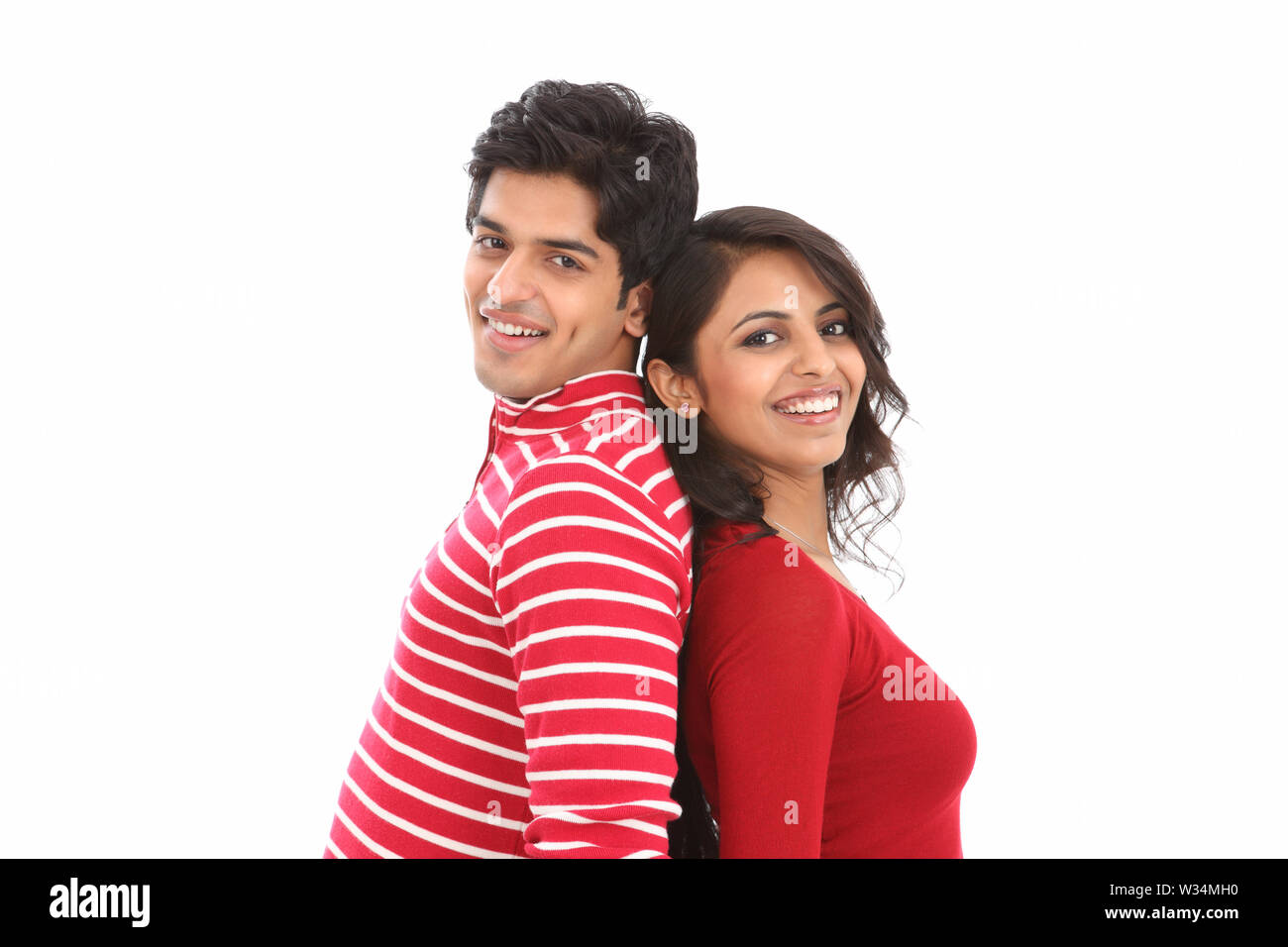 Couple standing back to back and smiling Stock Photo - Alamy