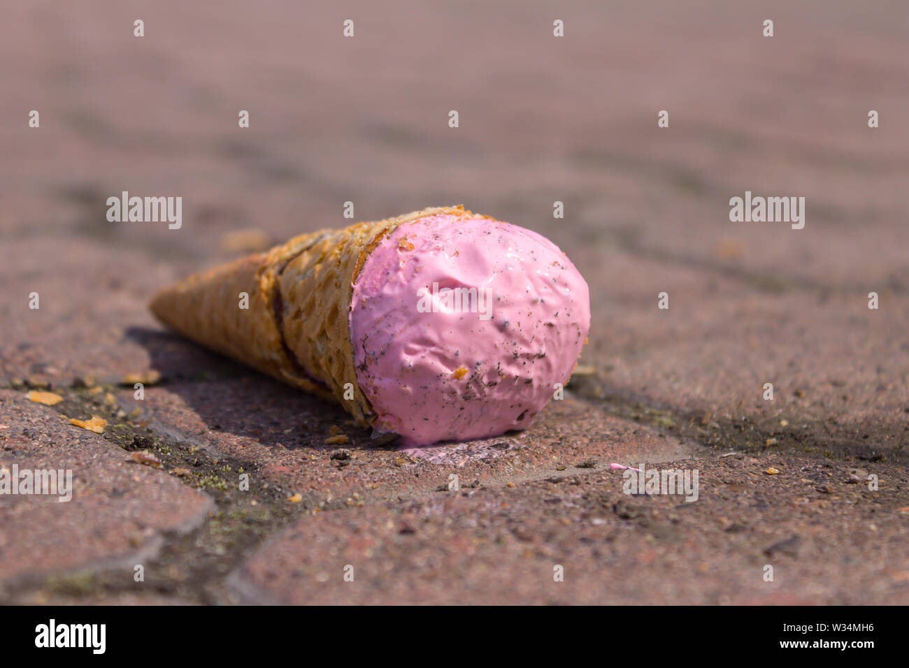 Pink ice cream is lying on the ground and melts in the sun Stock Photo ...