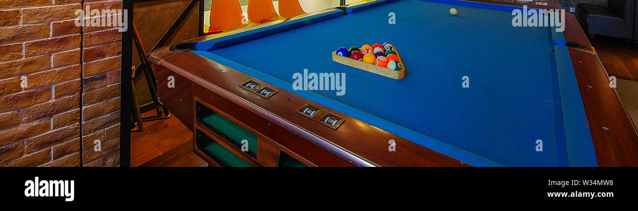Retro blue pool table and billiard balls set up in restaurant with ...