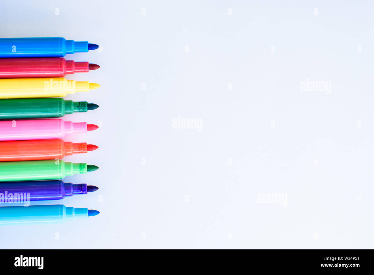 Open multicolored markers closeup on a white background. Place for text ...