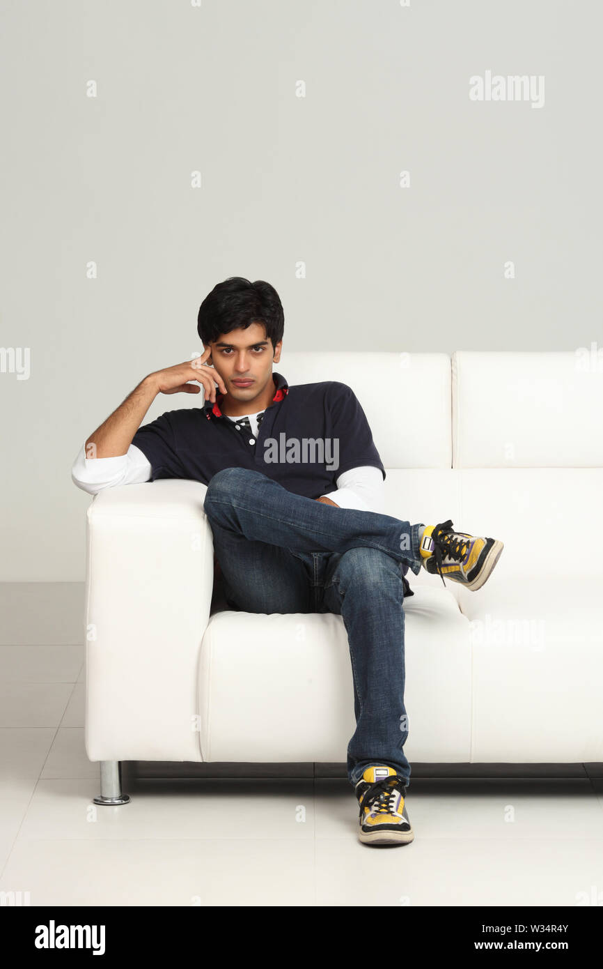 Portrait of a man sitting on couch Stock Photo - Alamy