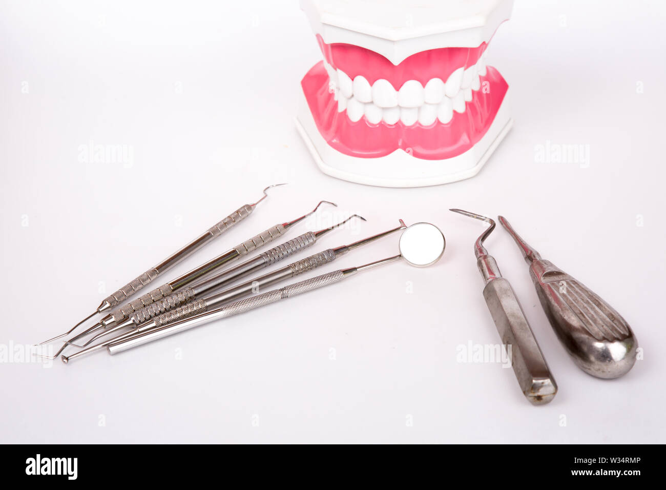 White teeth and dental instruments on white background Stock Photo - Alamy