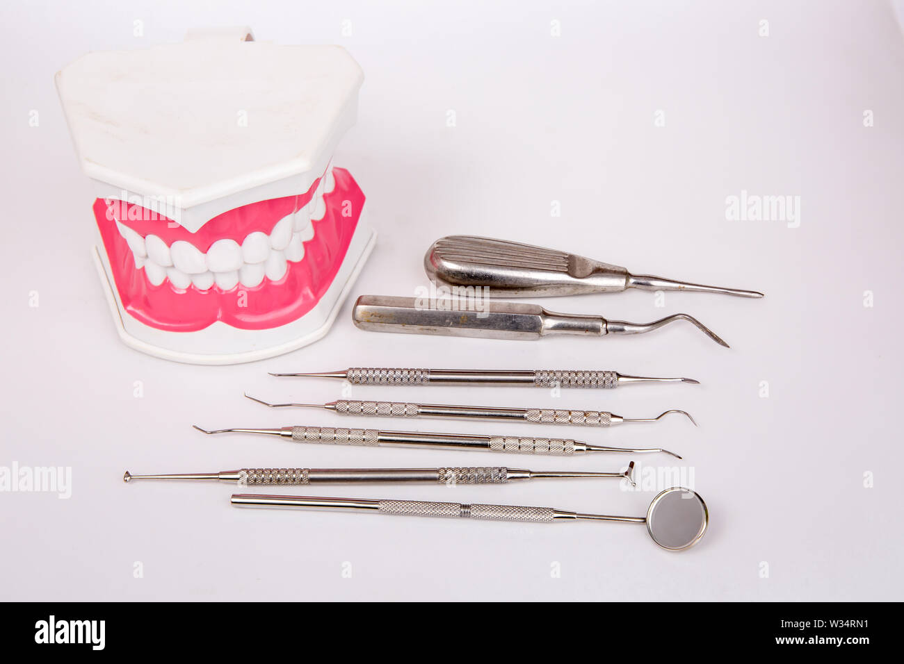 White teeth and dental instruments on white background Stock Photo - Alamy