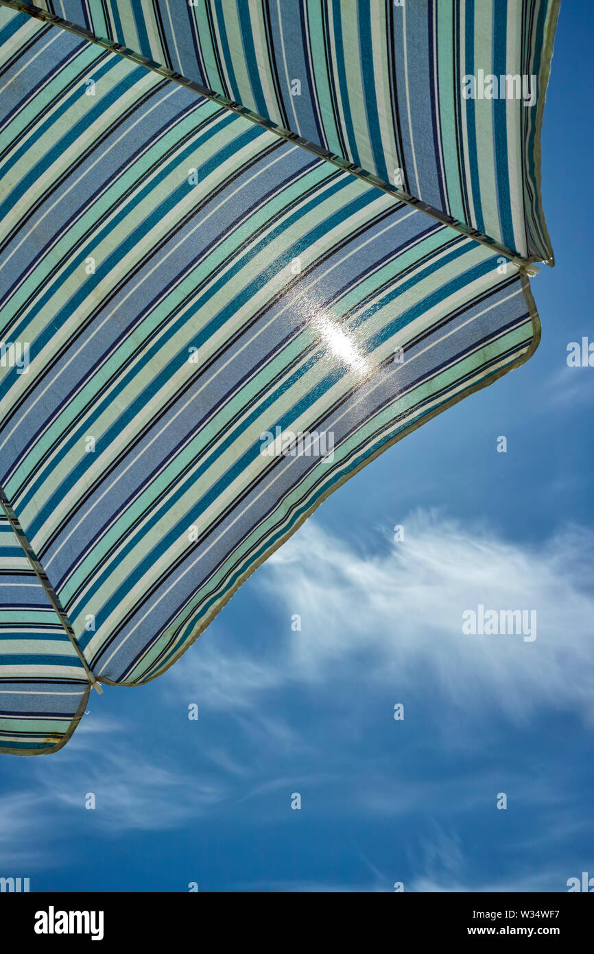 Sun umbrella for sun protention of skin and head on sunny beach in ...