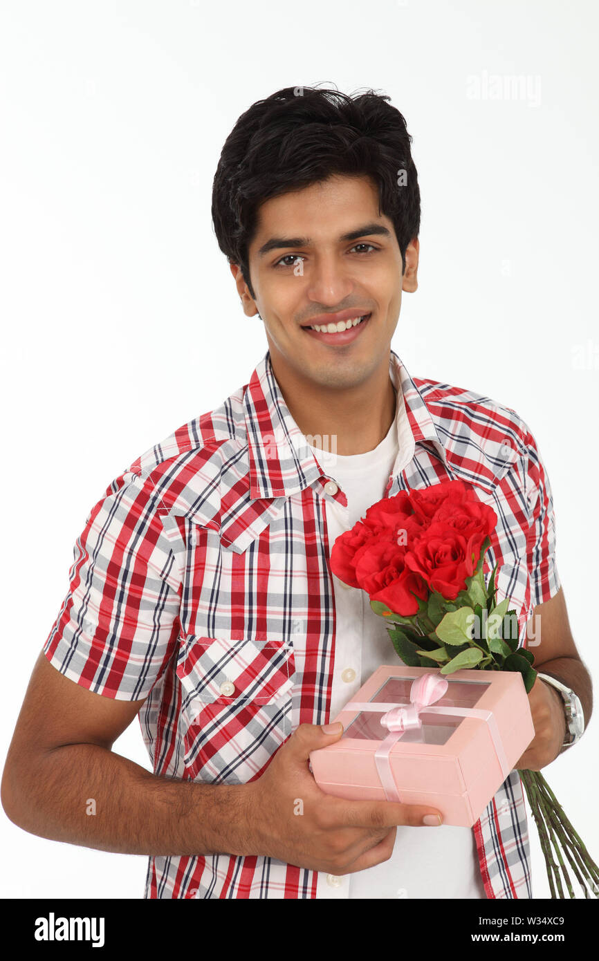 Portrait of a man holding bunch of flowers and gift box Stock Photo - Alamy