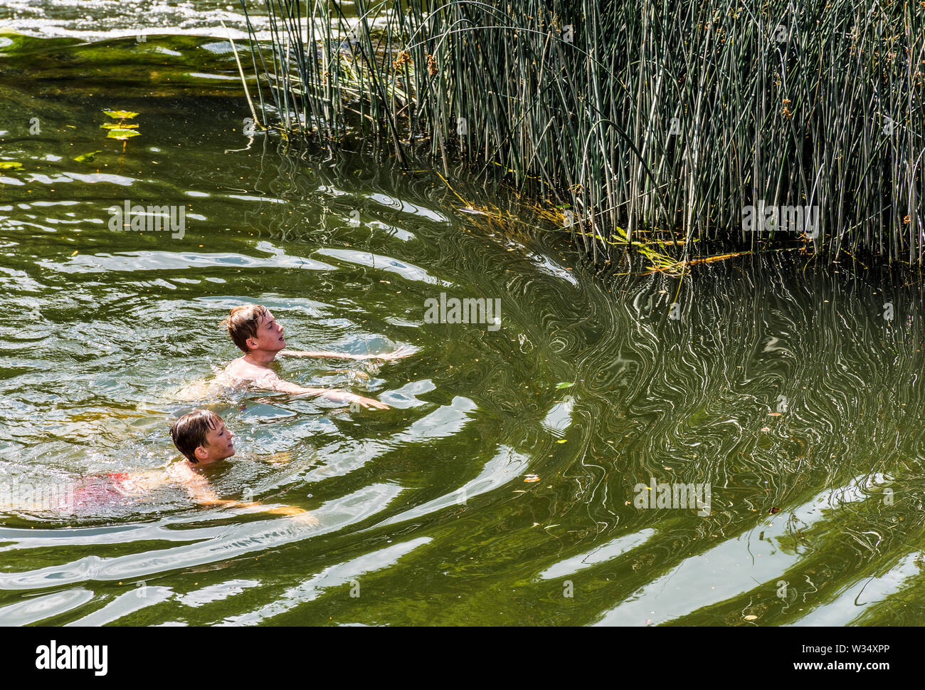 Bathampton, Somerset, England, UK weather. 12th July 2019. Boys cooling ...