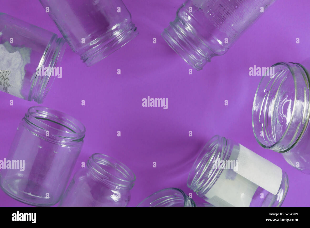 Isolated open glass jars, flat on violet purple background, blank empty ...