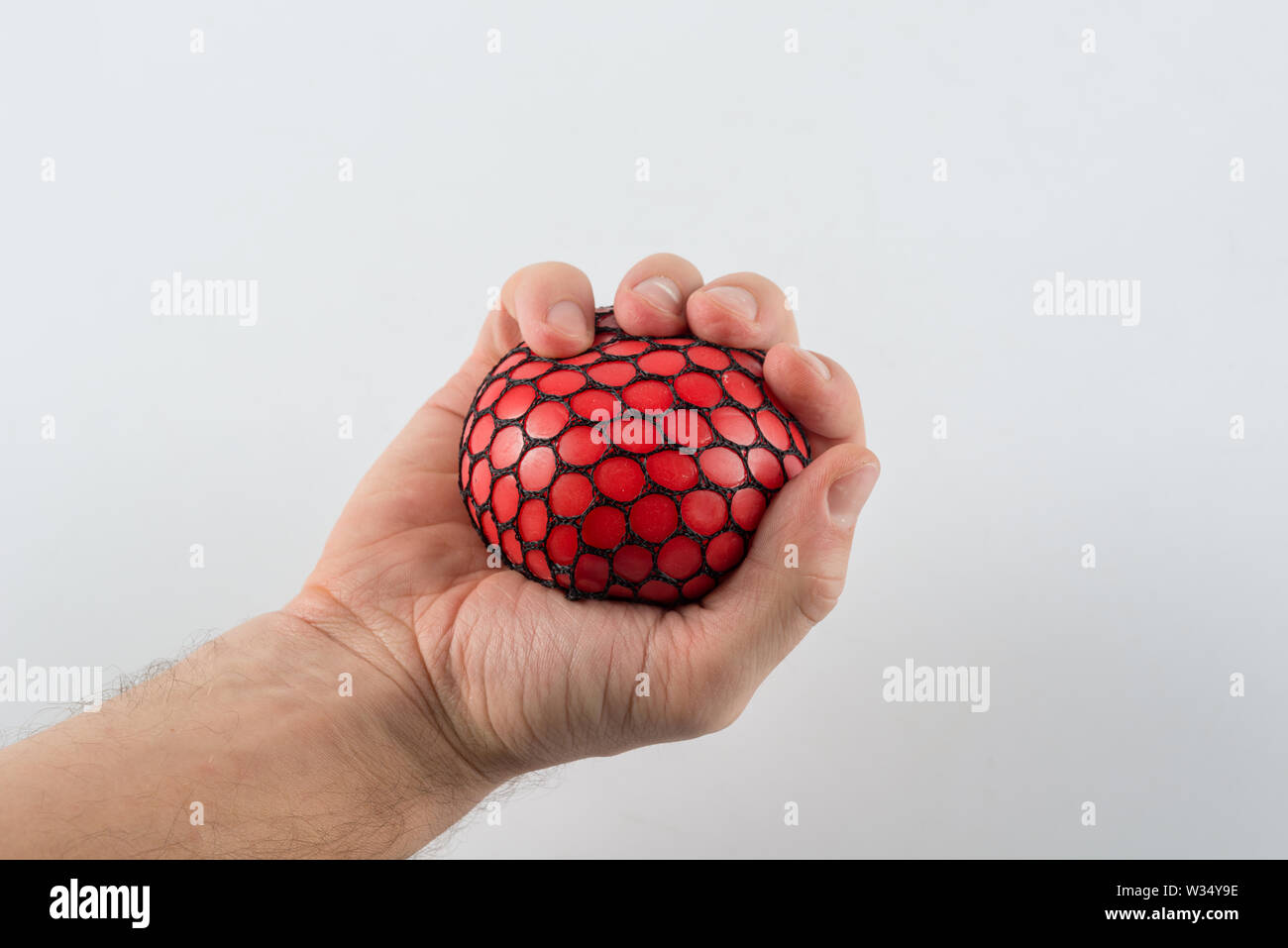 Male hand squeezing stress ball Stock Photo - Alamy