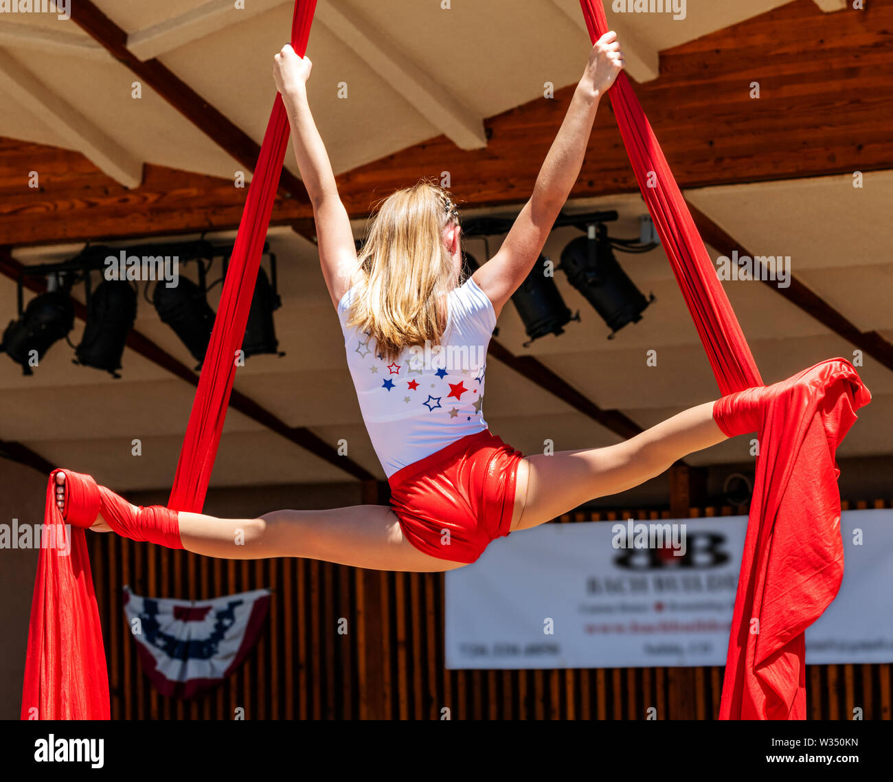 Young girl performing on aerial circus silks; Fourth of July ...
