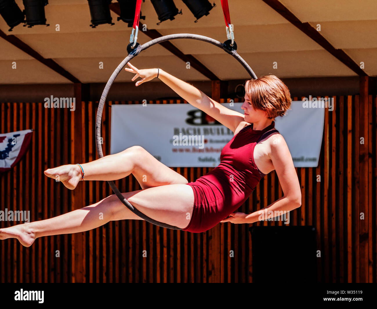 Young woman performing on circus aerial hoops rings Lyras; Salida ...