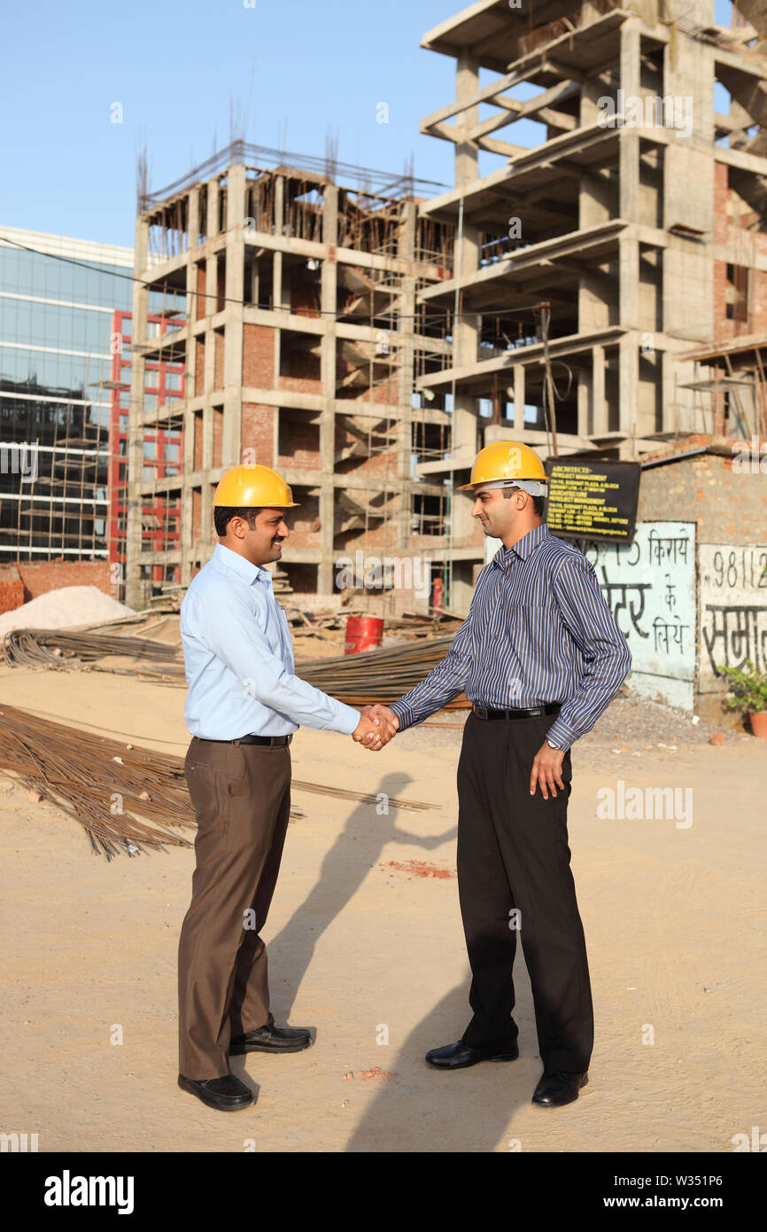 Two engineers shaking hands at a construction site Stock Photo - Alamy