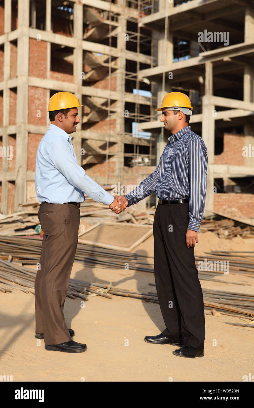 Two engineers shaking hands at a construction site Stock Photo - Alamy