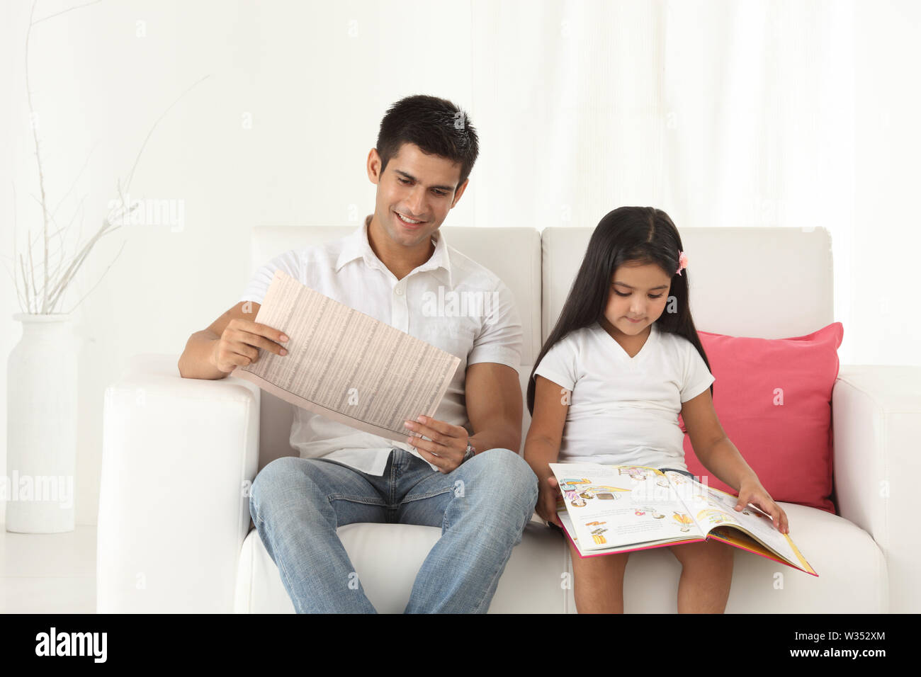 Daughter looking father reading newspaper hi-res stock photography and ...