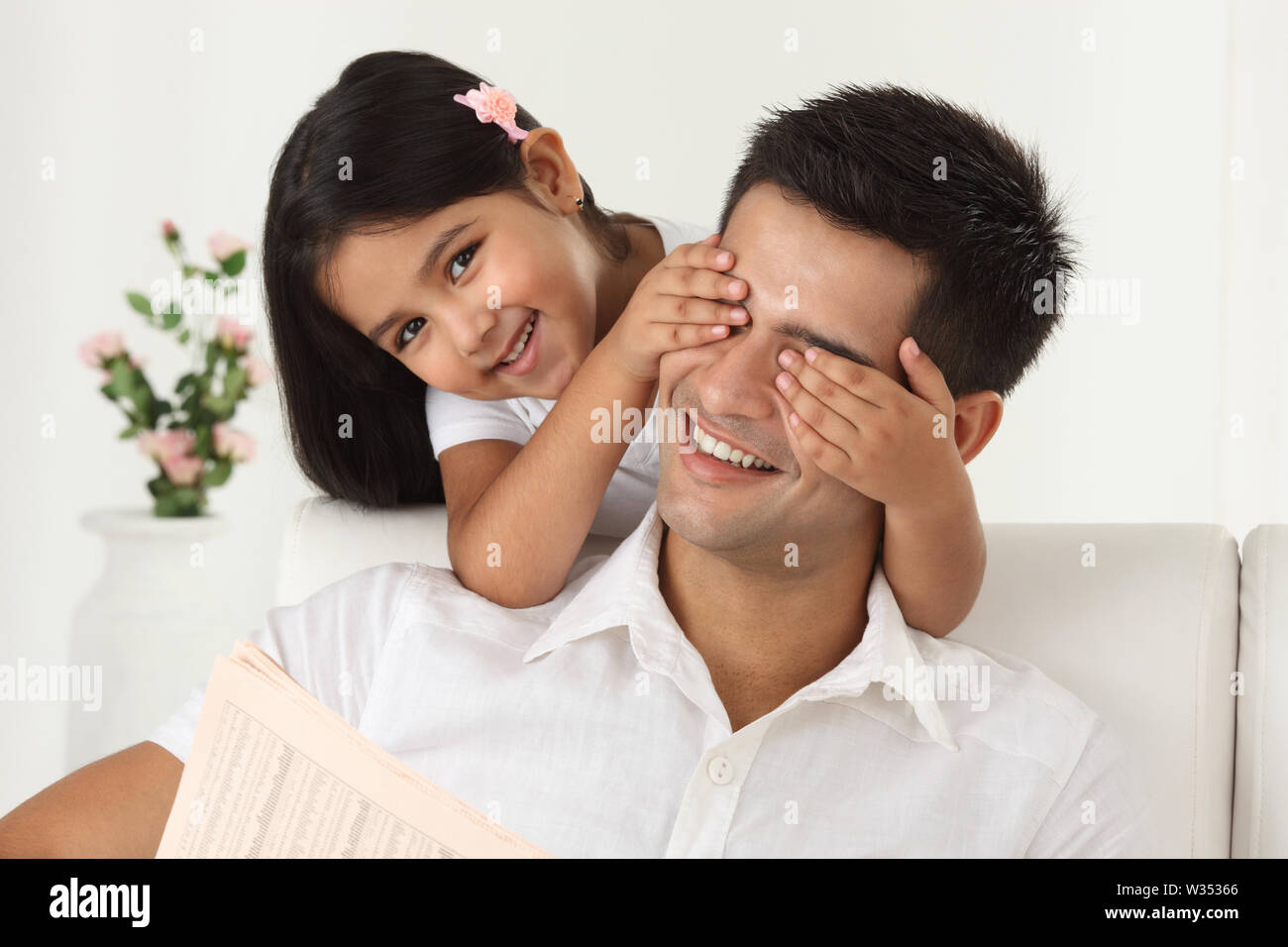 Indian girl covering her father eyes from behind Stock Photo - Alamy