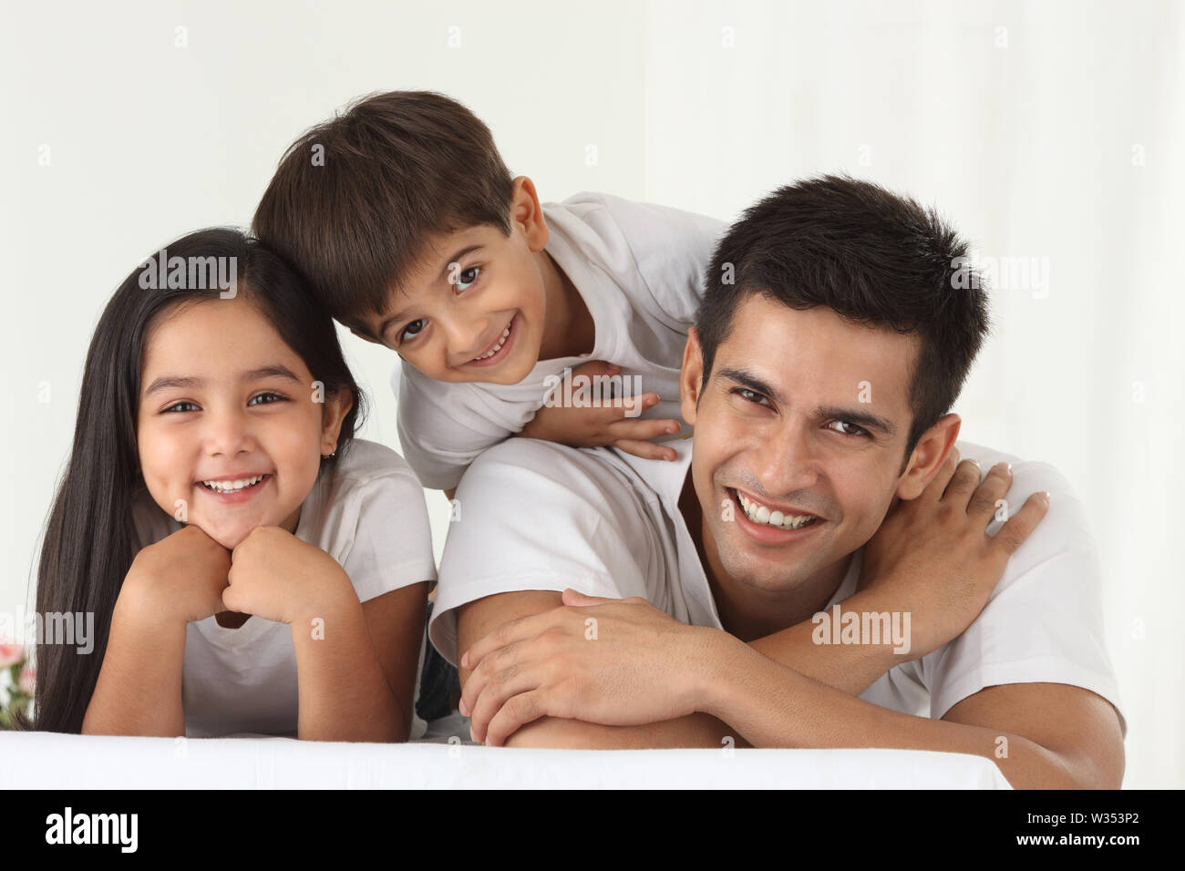 Family with his two children smiling on the bed Stock Photo - Alamy