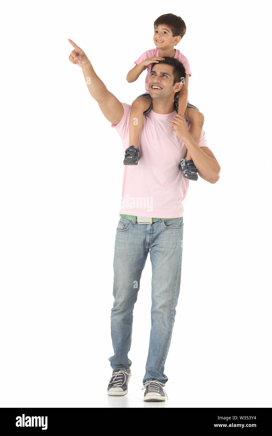 Man carrying his son on shoulders and pointing Stock Photo - Alamy