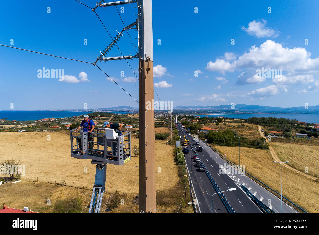Chalkidiki, Greece - July 12, 2019: Electricians are climbing on ...