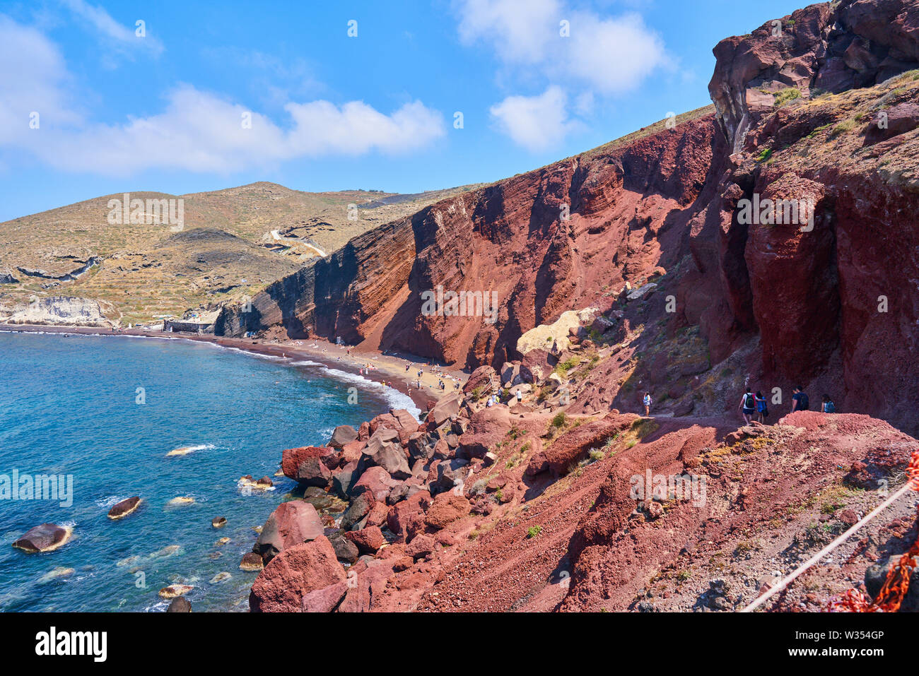 Tourists visit the Red Beach in Akrotiri near Oia, Santorini , Greece ...