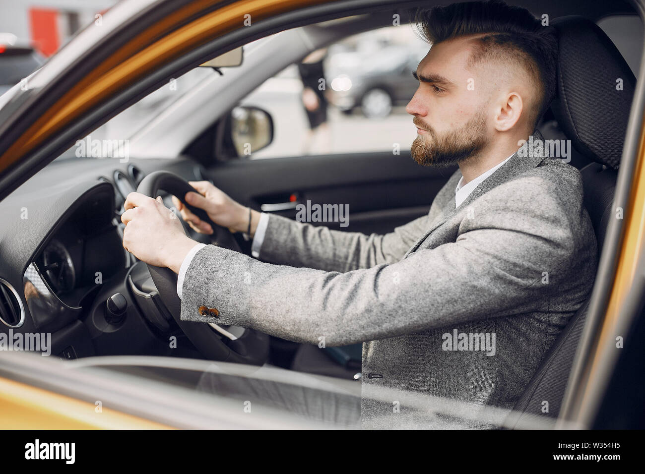 Handsome and elegant man in a car salon Stock Photo - Alamy
