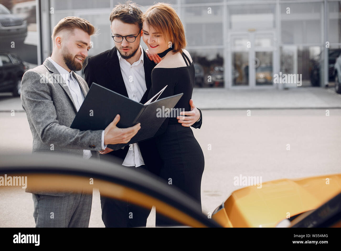 Stylish and elegant couple in a car salon Stock Photo - Alamy