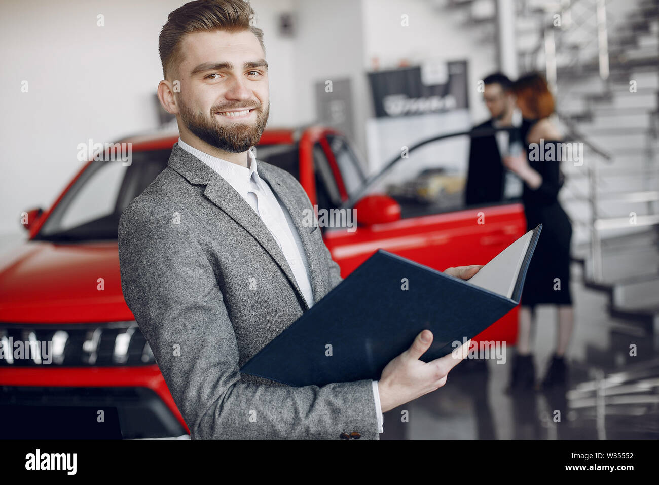 Stylish and elegant couple in a car salon Stock Photo - Alamy