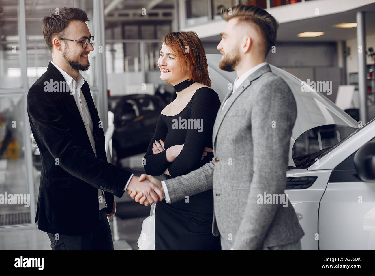 Stylish and elegant couple in a car salon Stock Photo - Alamy