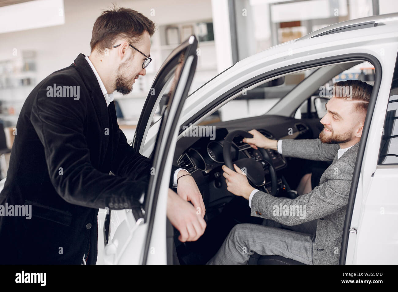 Stylish and elegant couple in a car salon Stock Photo - Alamy