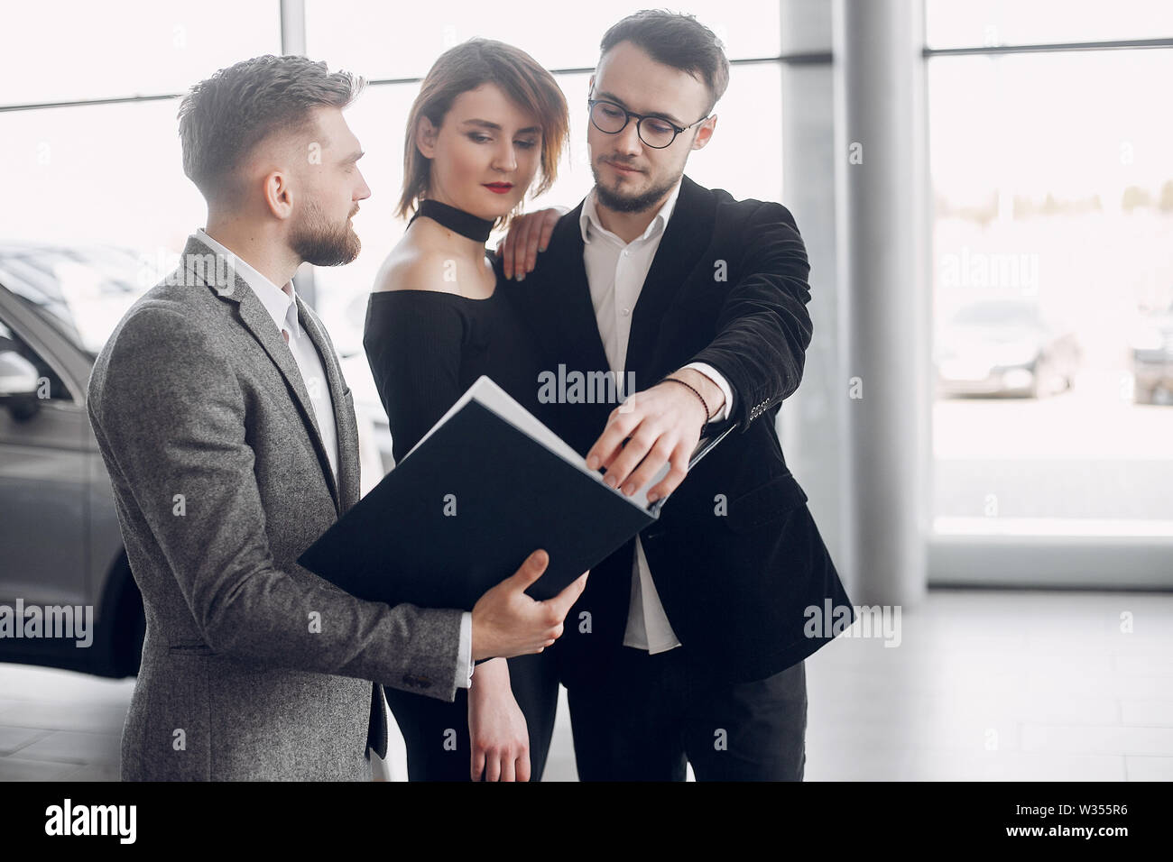 Stylish and elegant couple in a car salon Stock Photo - Alamy