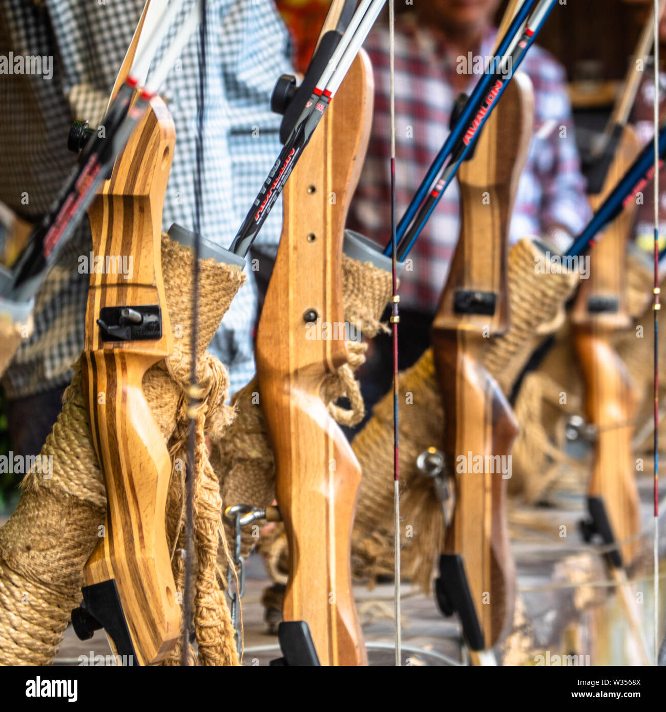 Wooden bows set up in a row at a shooting gallery at the fair, with a ...